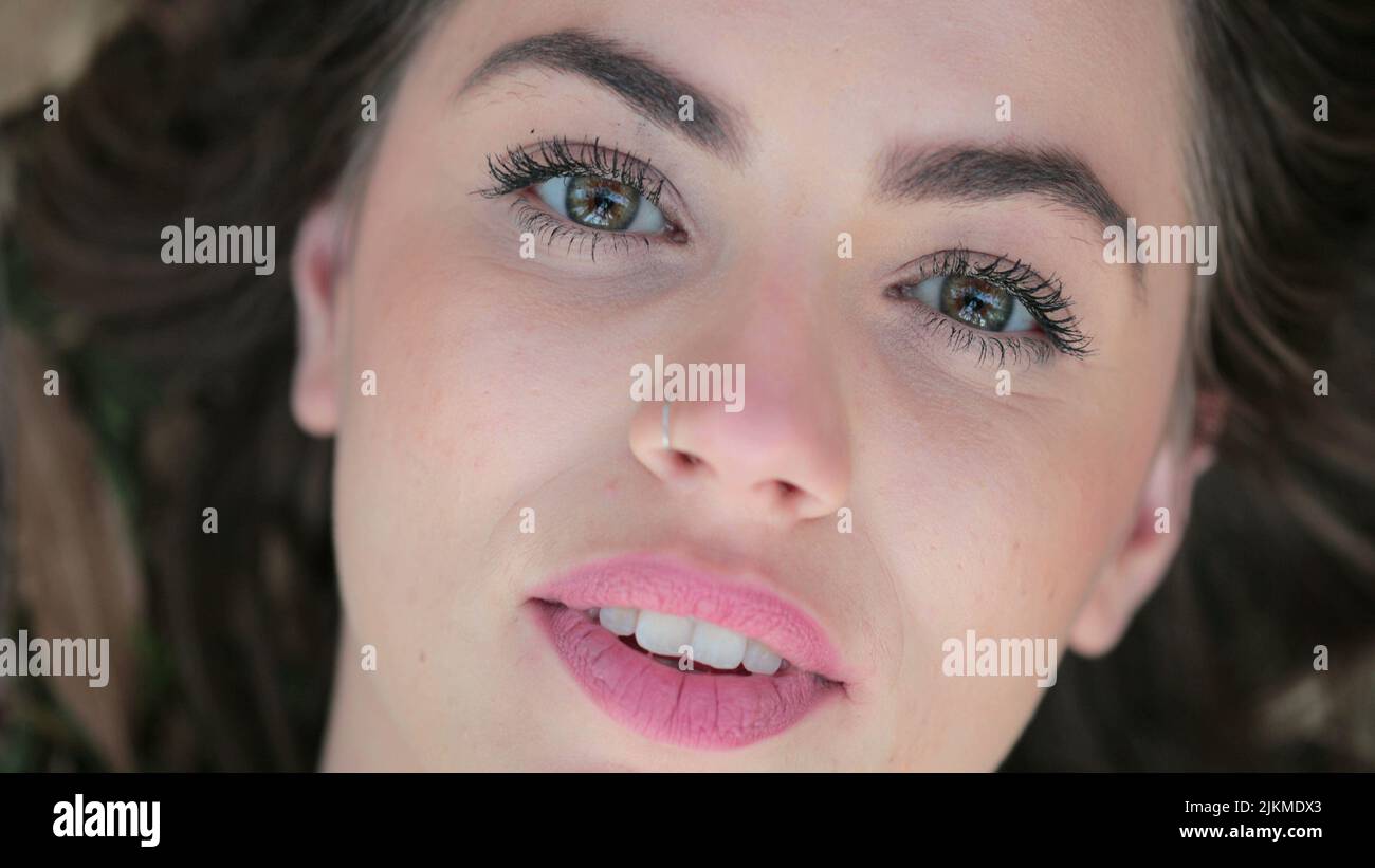 Girl face looking to camera closes eye Woman face with green eyes ...