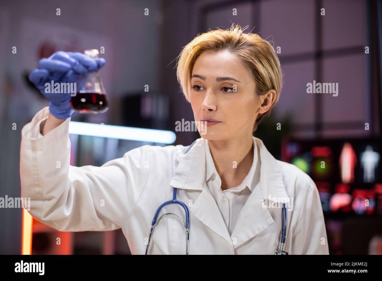 Modern medical research laboratory: female scientist working with flask ...