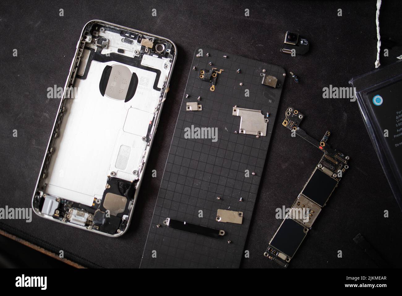A closeup shot of a destroyed phone, with removed screen and chips out ...