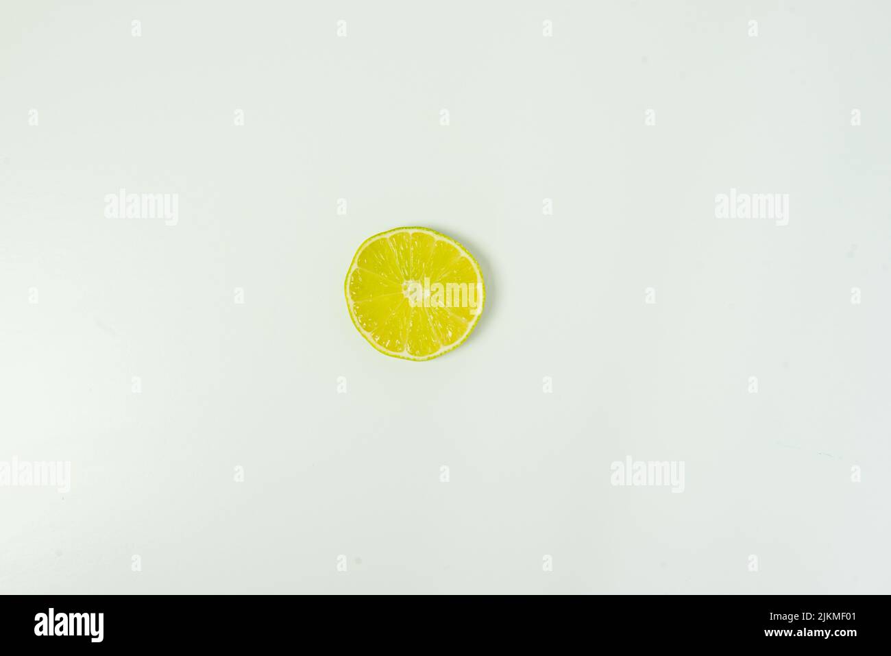 Single lime slice in center of white background Stock Photo - Alamy