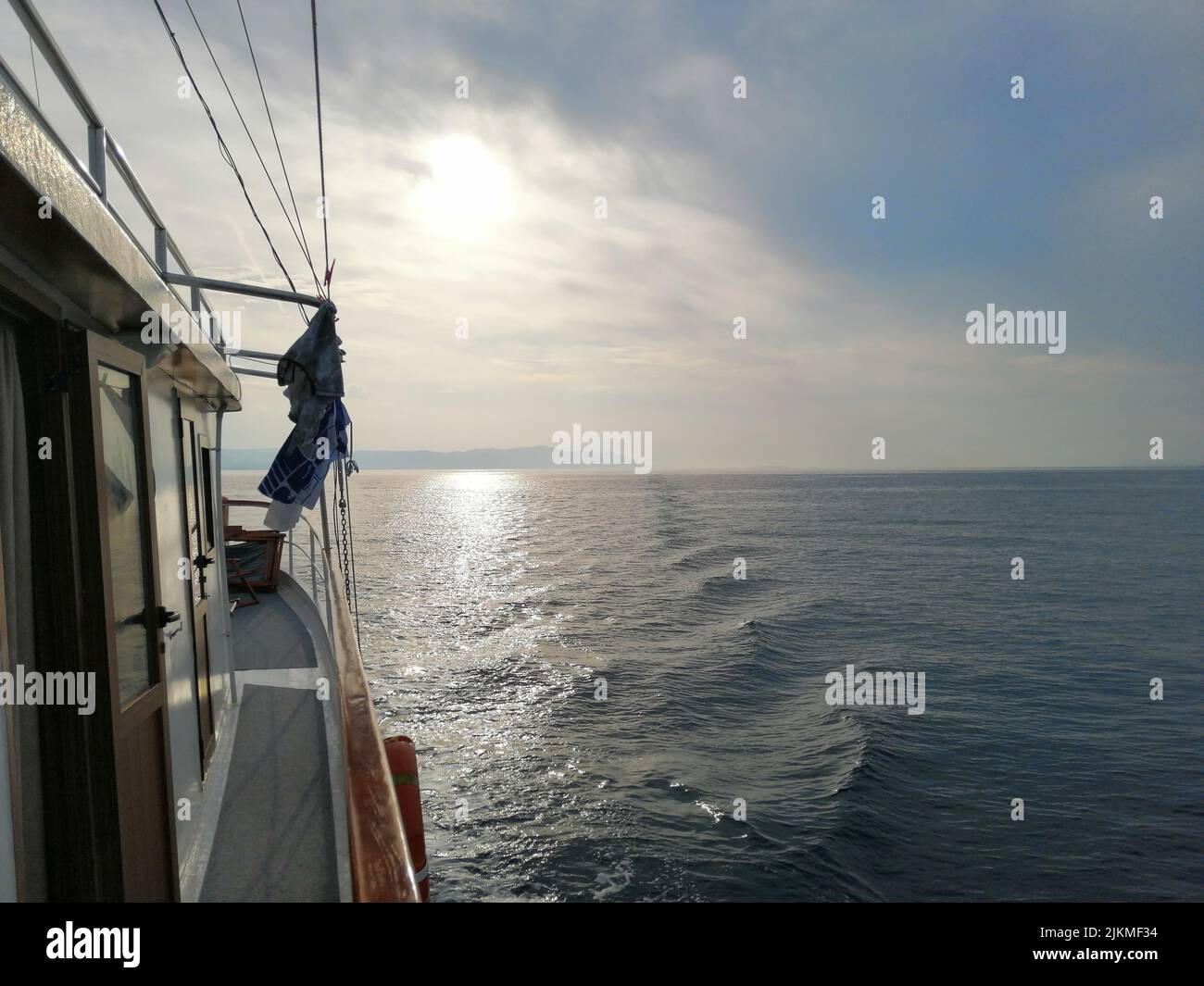 A scenic view of the blue seascape under a cloudy sky seen from a boat ...