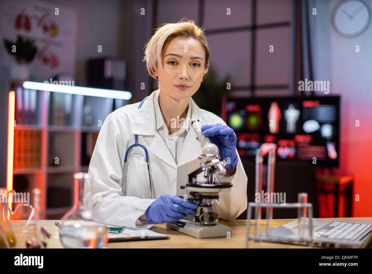 Attractive young female scientist supervisor using microscope research ...