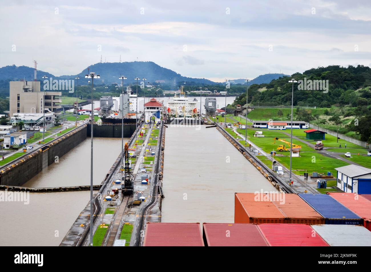 Merchant ships pass the locks of the Panama Canal. Container ship ...