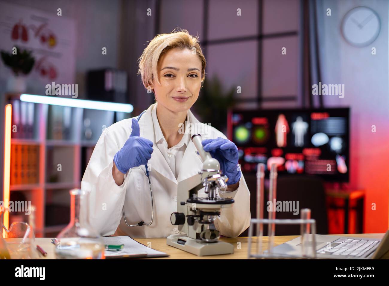 Attractive young female scientist supervisor using microscope research ...