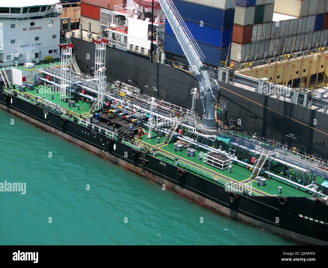 Bunkering tanker container ship in port Stock Photo - Alamy