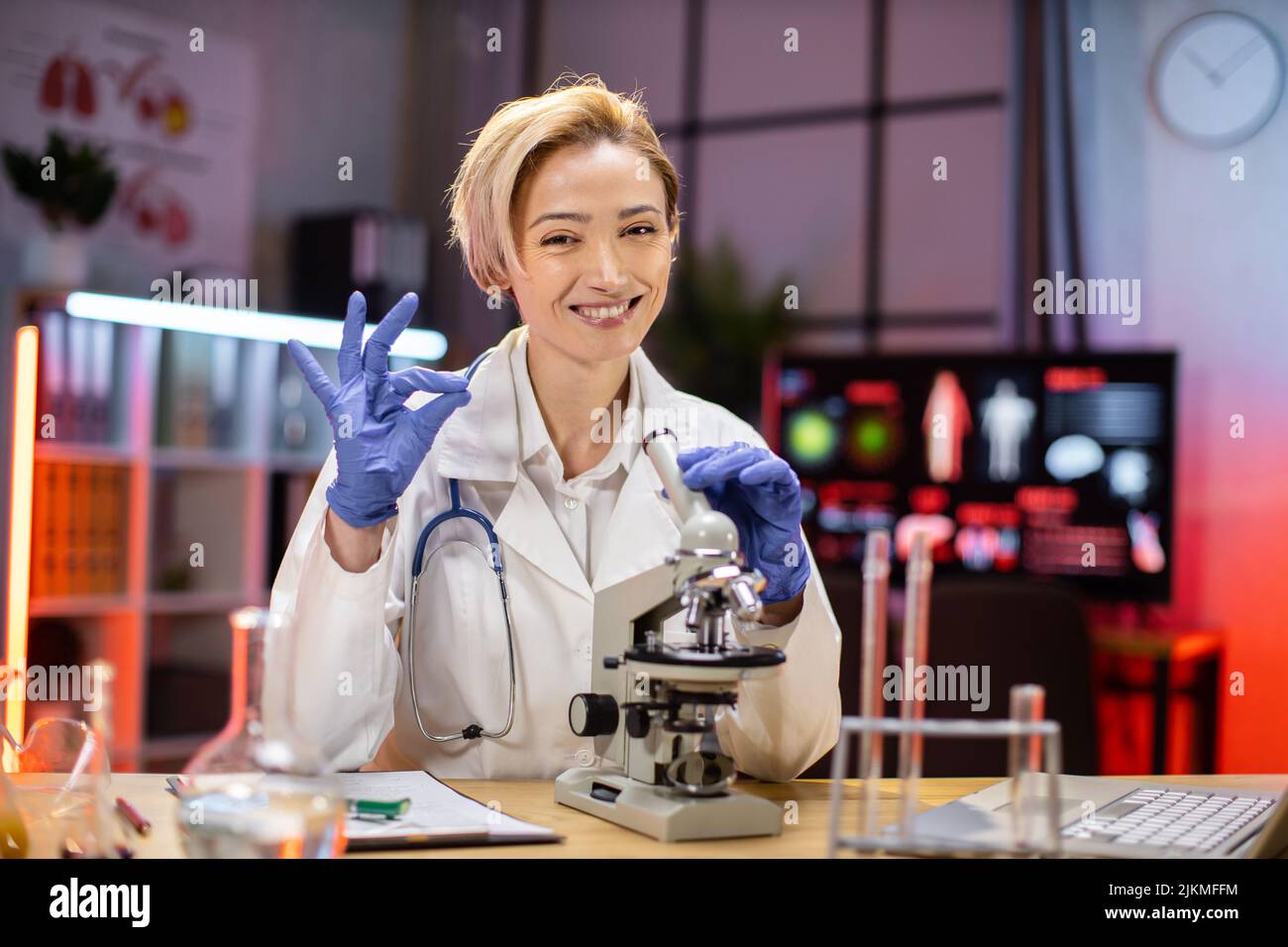 Attractive young female scientist supervisor using microscope research ...