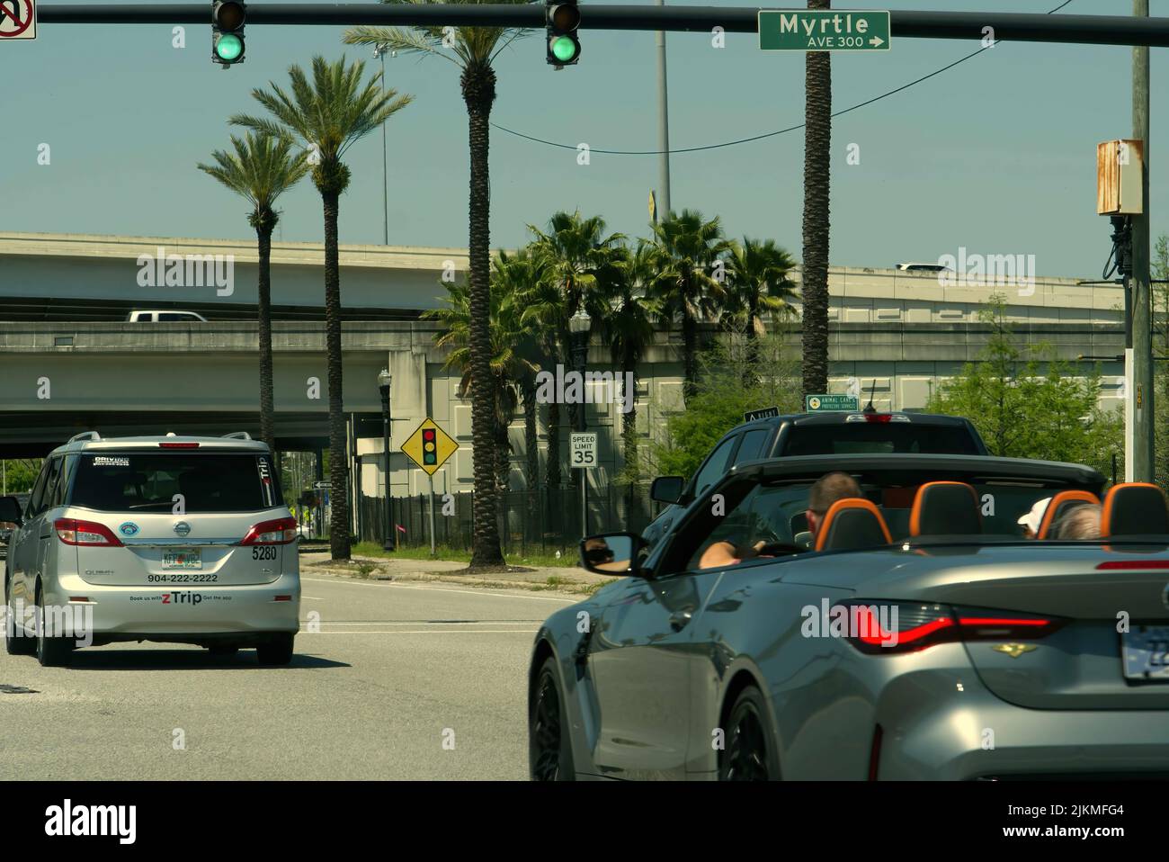 A Z Trip vehicle passing under a bridge on the street with palm trees ...