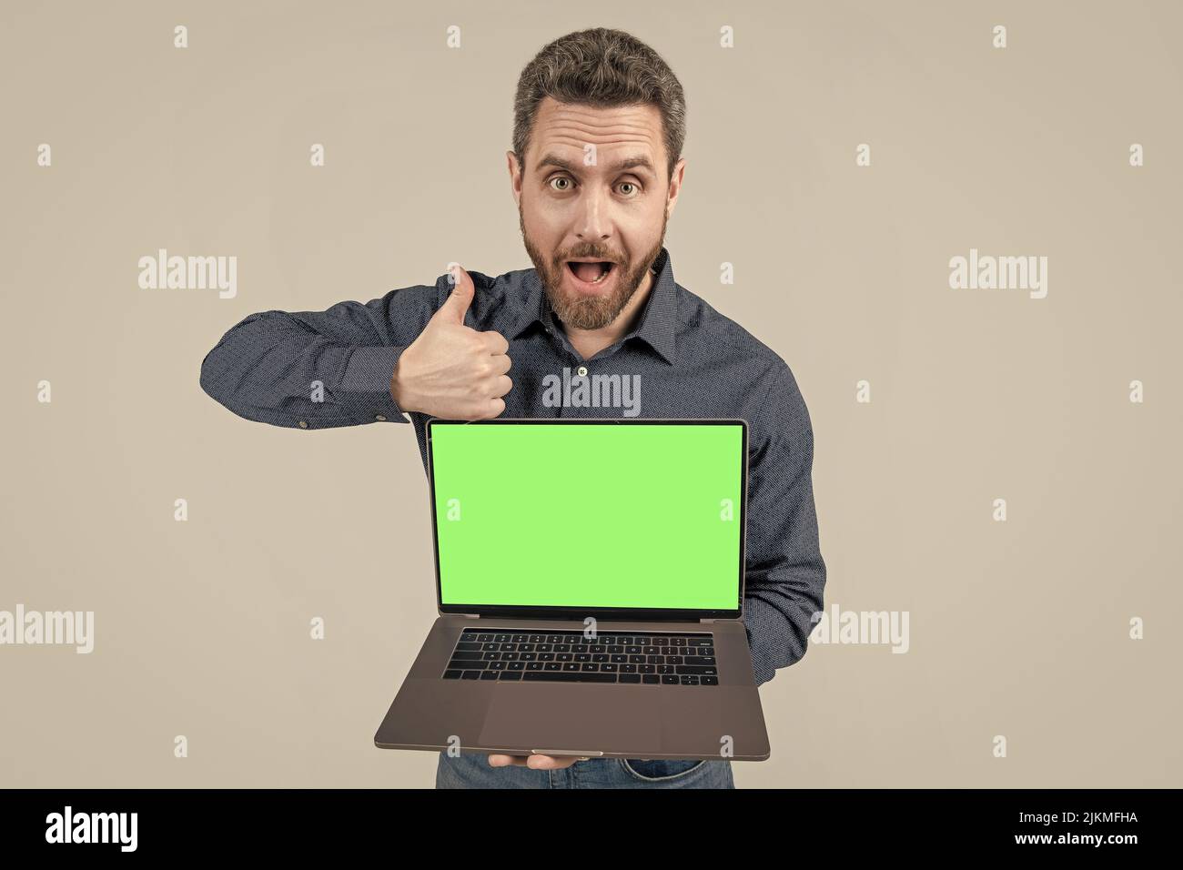 surprised mature man businessman presenting computer for copy space ...