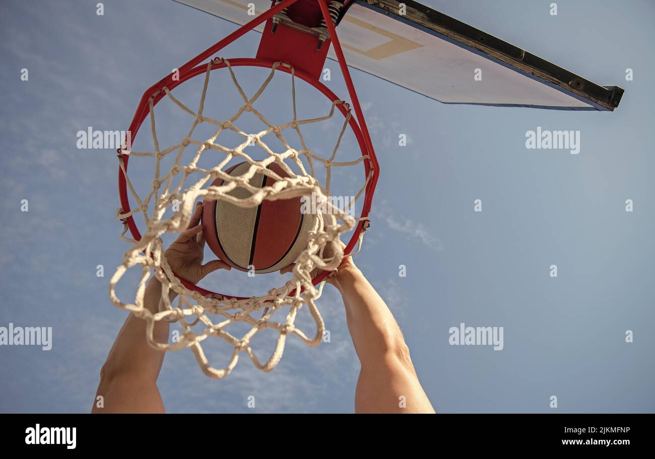 basketball ball flying through basket in players hands on sky ...