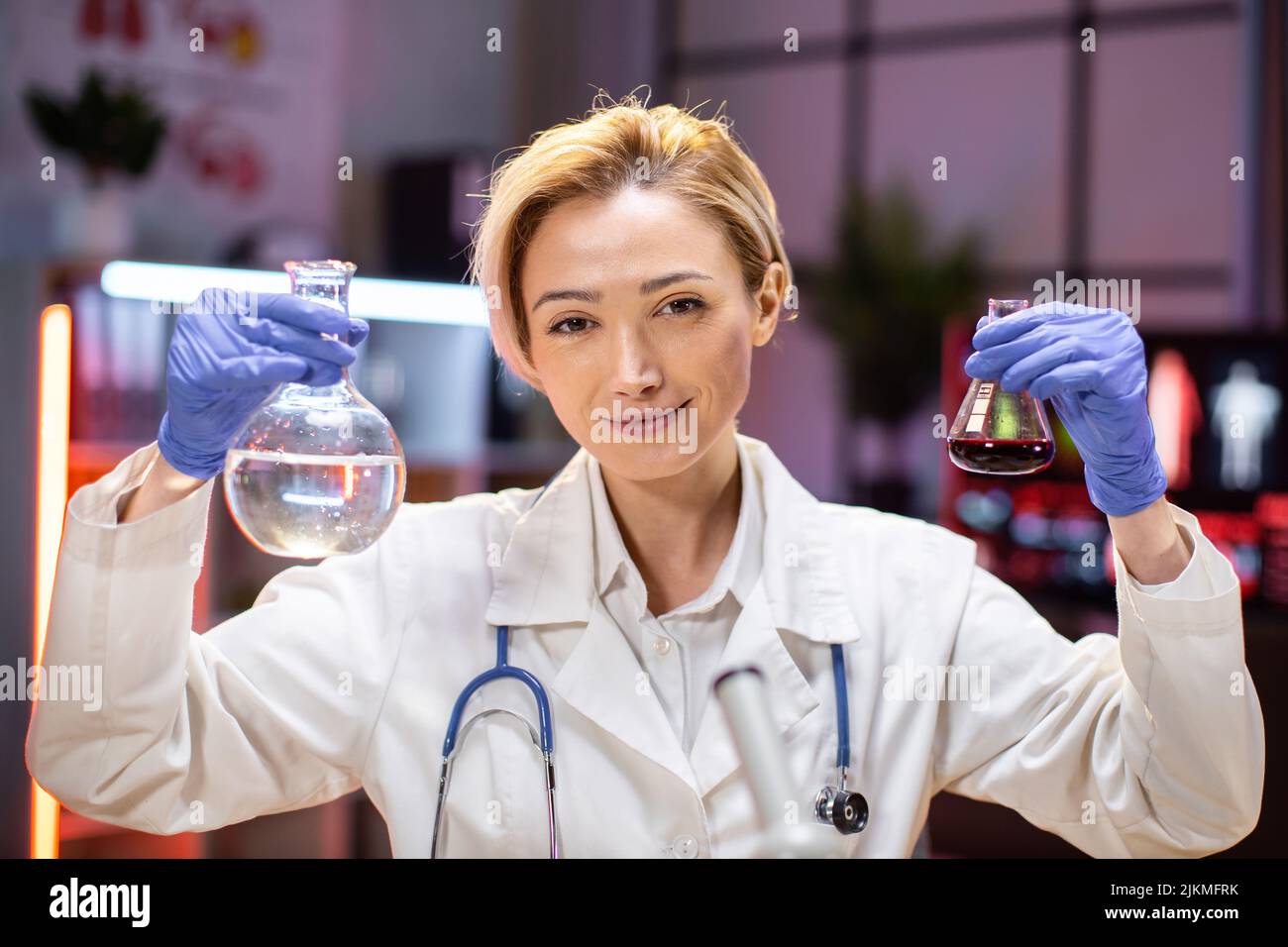 Positive female scientist or medical in lab coat holding test tube with ...