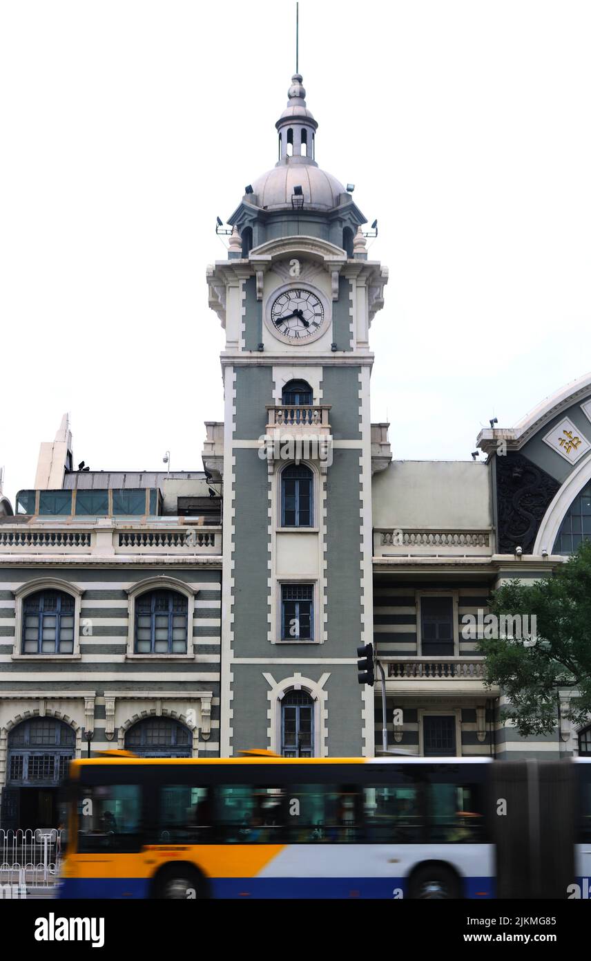 A vertical shot of a bus driving against the old Beijing railway ...
