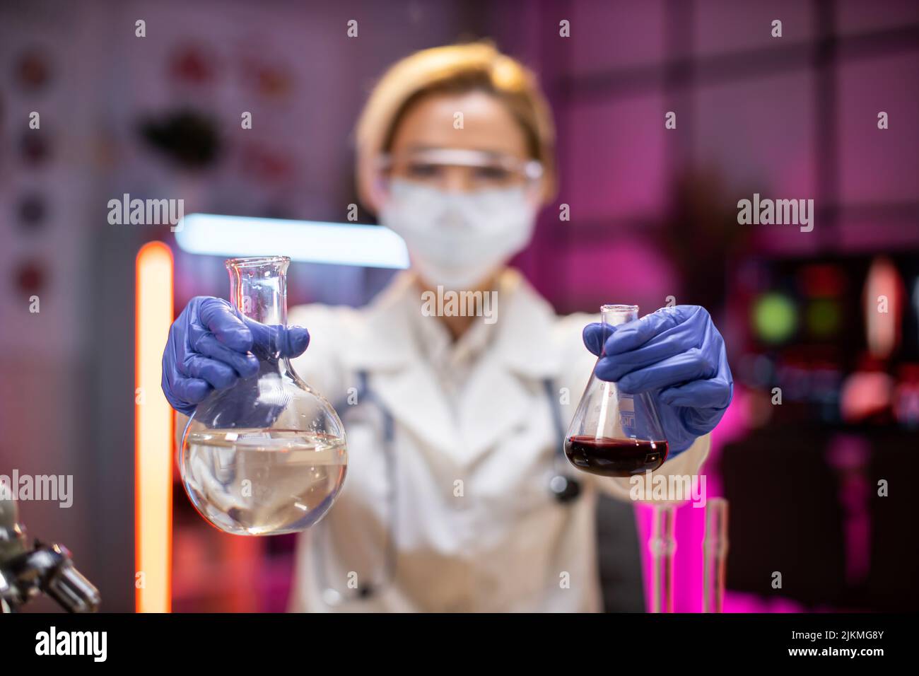 Female scientist testing experiment in a science lab where she holding ...