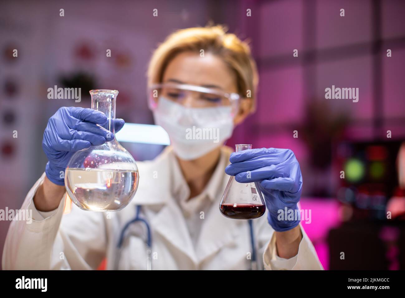 Female scientist testing experiment in a science lab where she holding ...