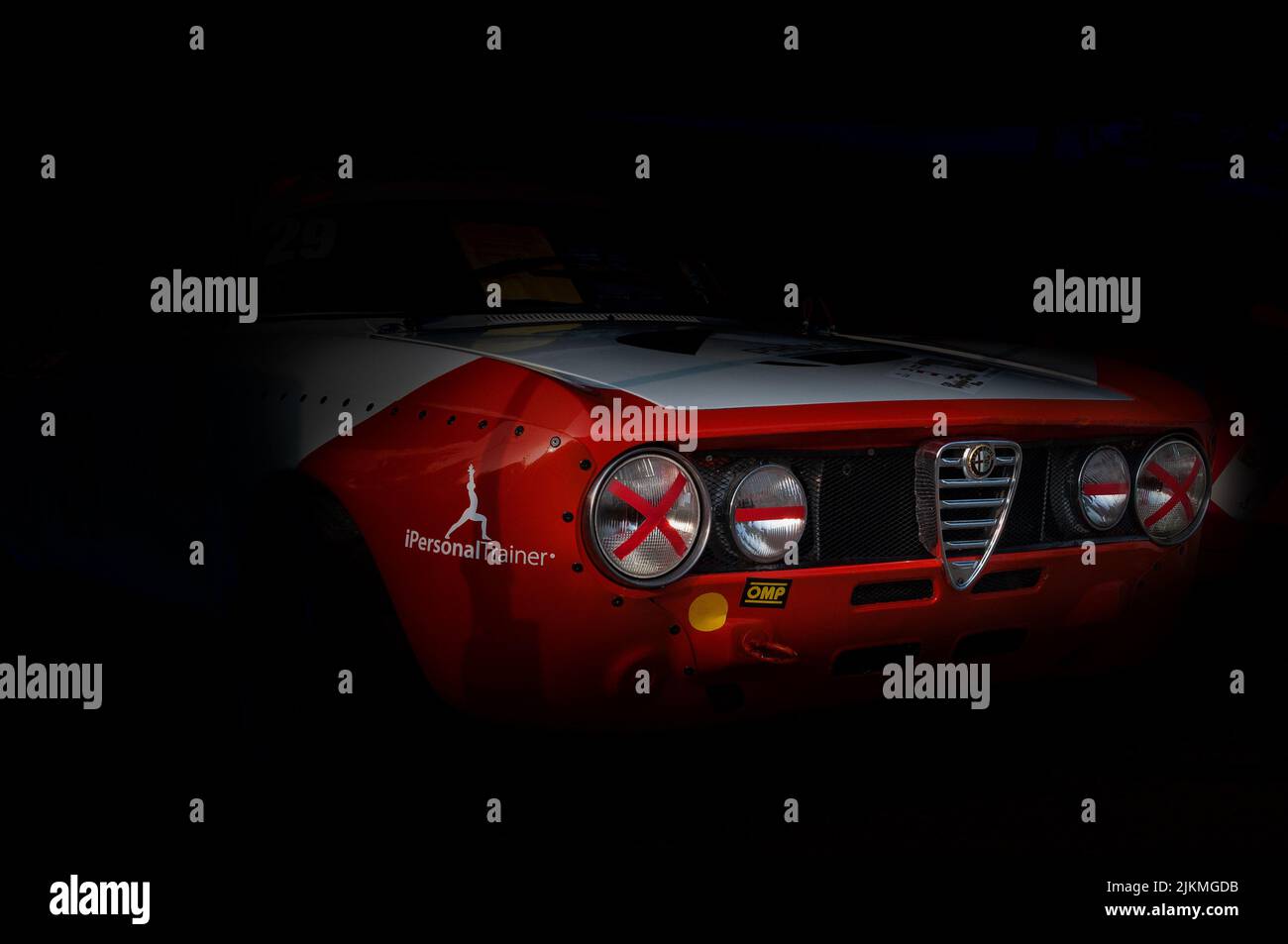 A closeup shot of an old red Alfa Romeo Junior Reply GTA racing car ...