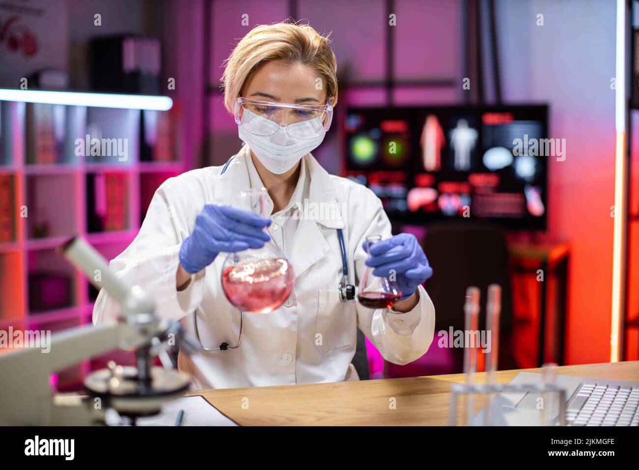 Female doctor microbiologist using microscope with vacuum tubes for ...