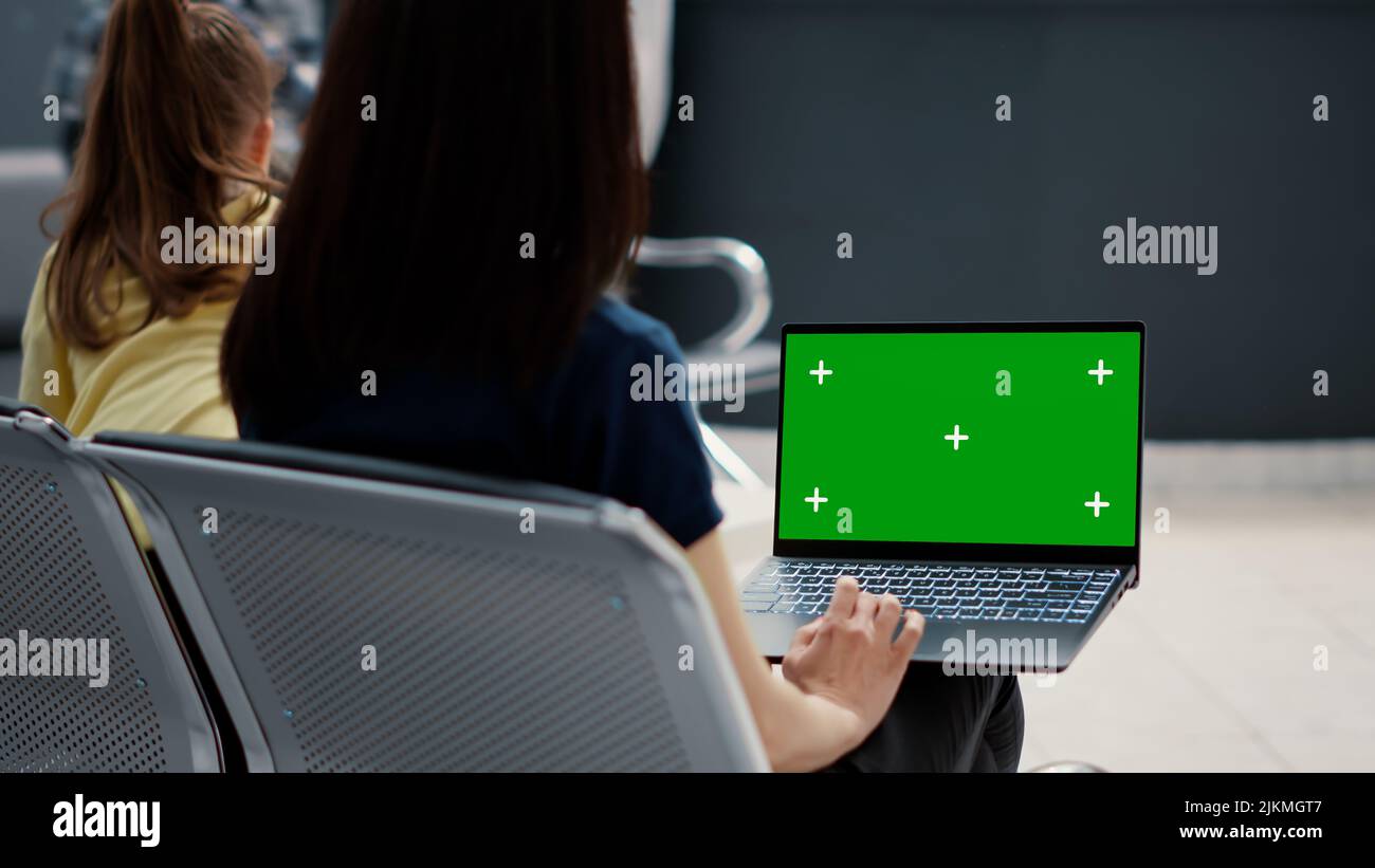 Mother and small kid holding laptop with greenscreen background in ...