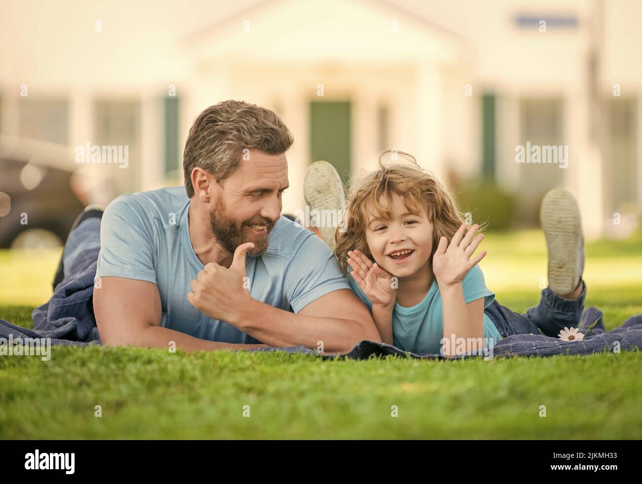 happy father with son relax together on green park grass show thumb up ...