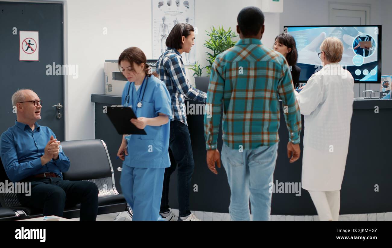 Busy reception desk with many patients waiting to attend consultation ...