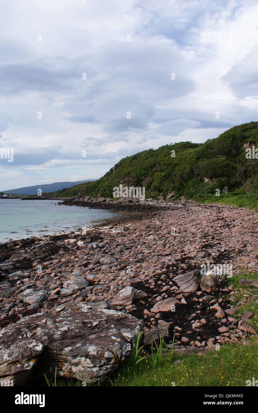 A scenic view of rocky shore and mountain landscape in Scotland under a ...