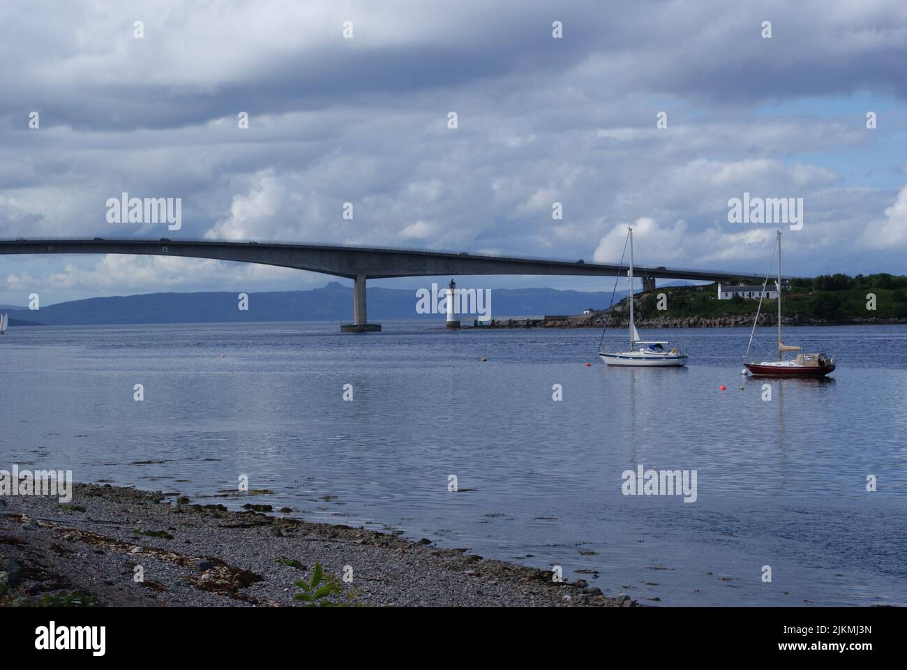 A beautiful view of boats moored on the sea near a bridge in Scotland ...