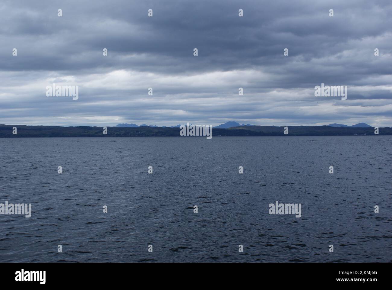 A beautiful view of sea waves with mountains background under a cloudy ...