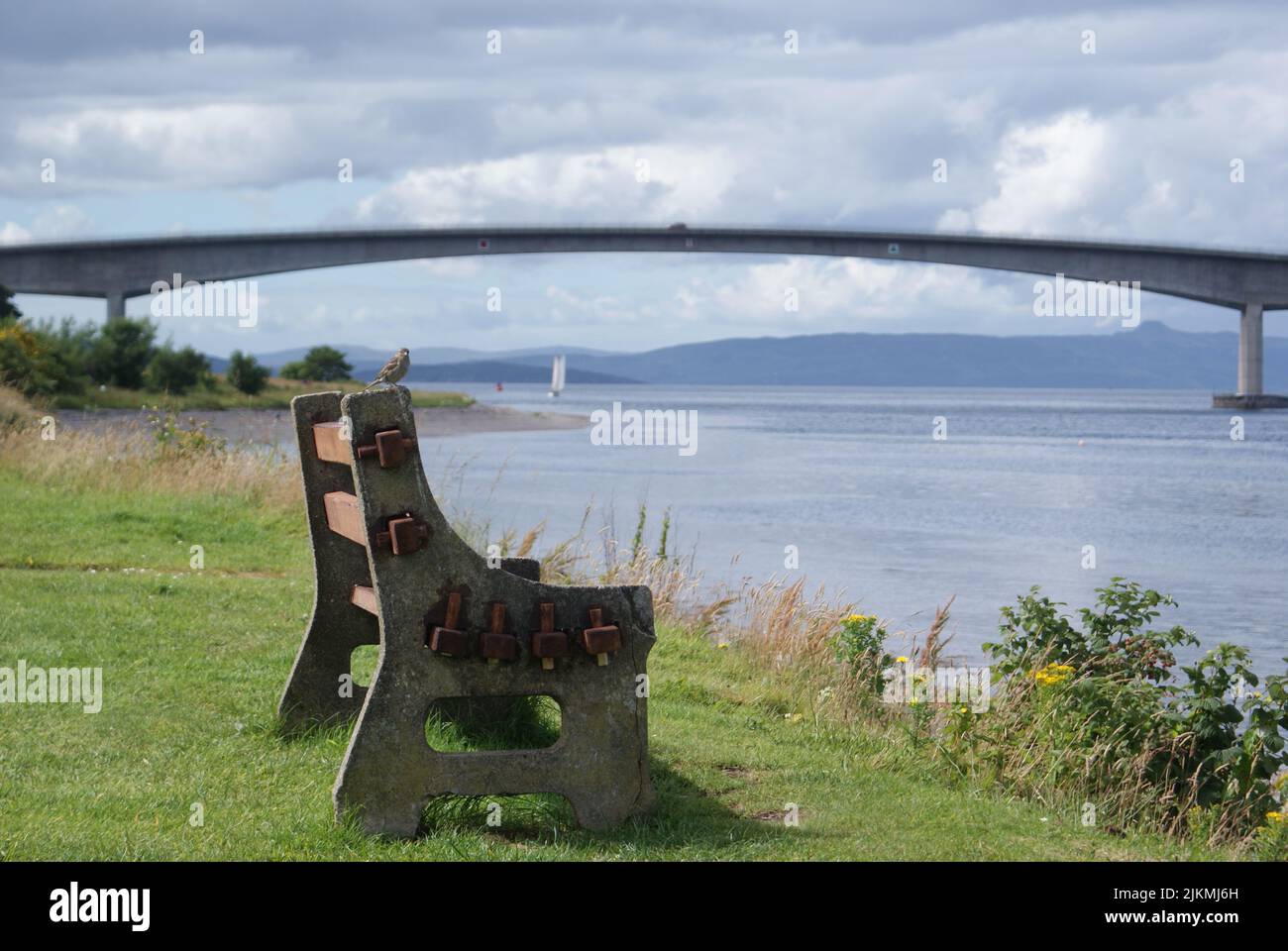 An old empty bench in front of the sea with bridge background in ...