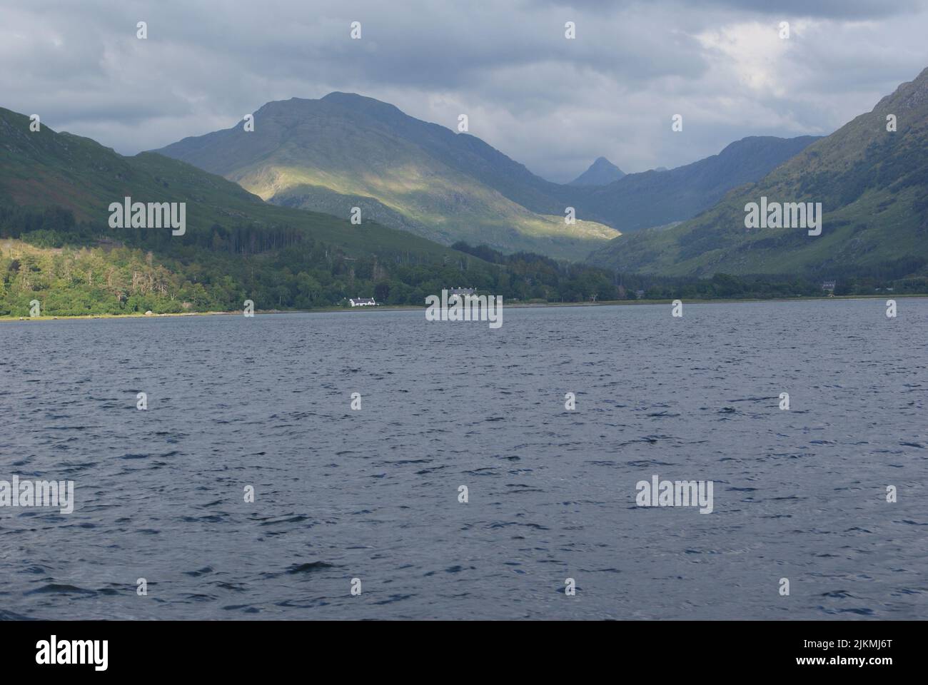 A beautiful view of sea waves with mountains background under a cloudy ...
