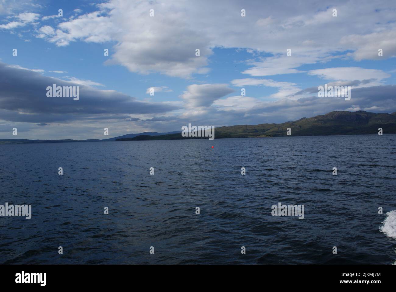 A beautiful view of sea waves with mountains background under a cloudy ...