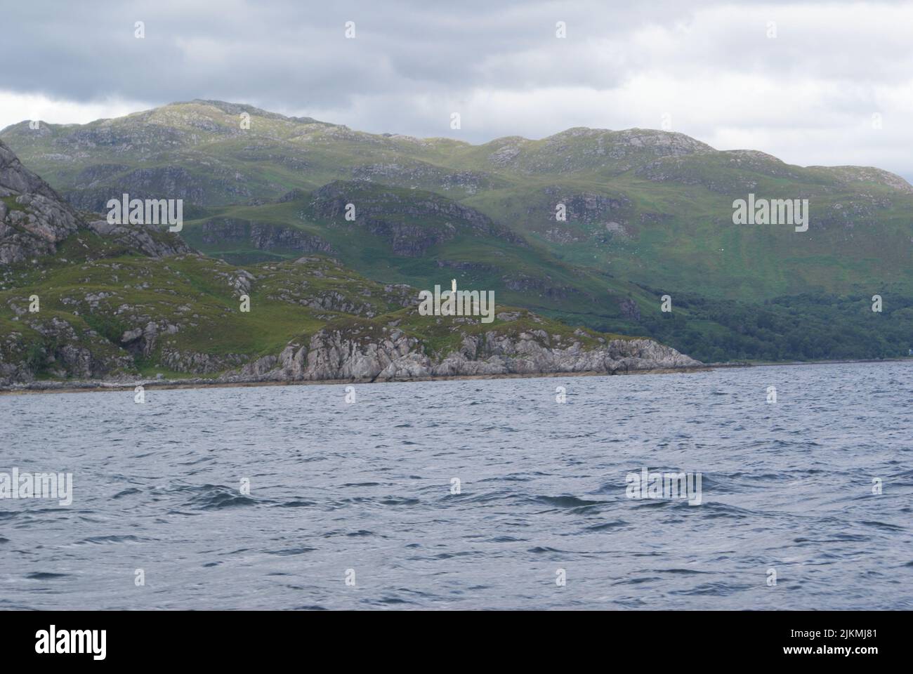 A beautiful view of sea waves with mountains background under a cloudy ...