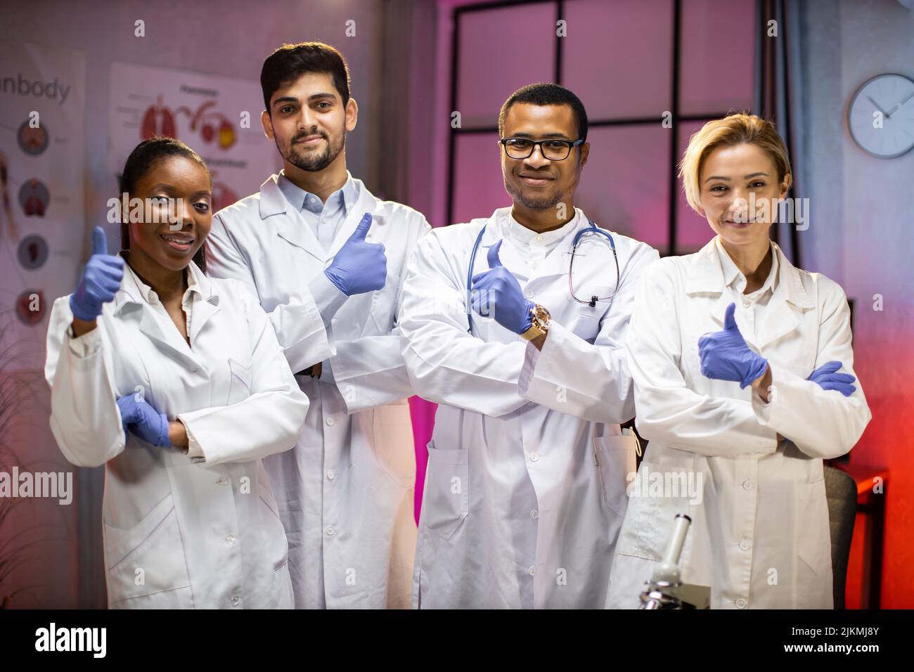 Smiling group of scientists in modern laboratory with male african american leader, mix race ...
