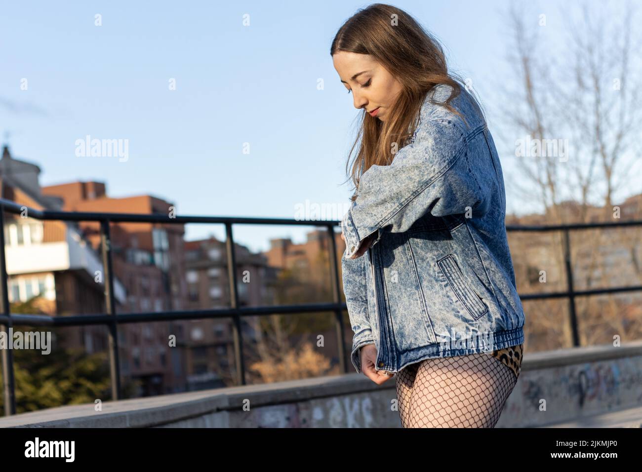 Woman putting on jacket hi-res stock photography and images - Alamy