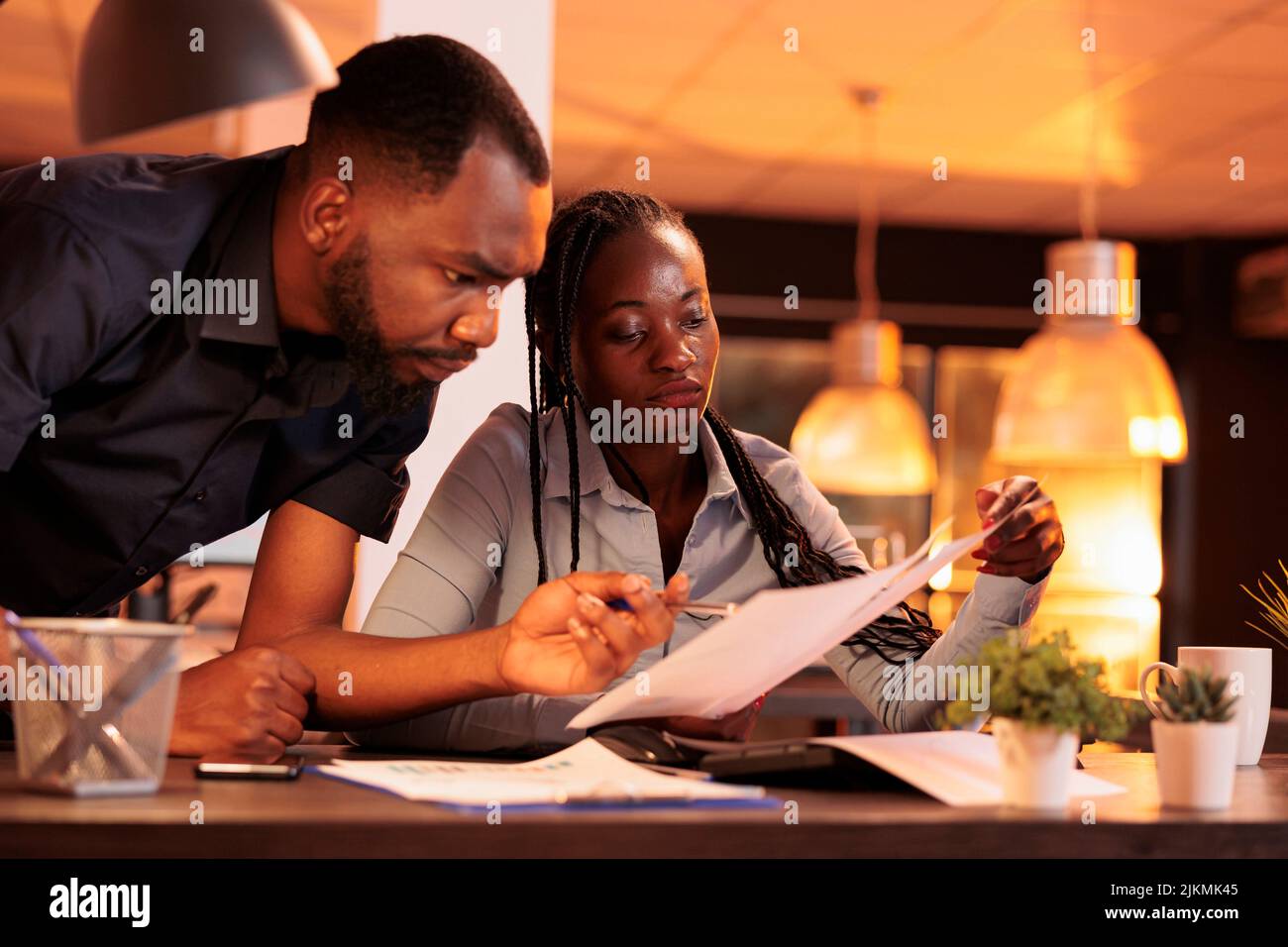 Team of african american business partners analyzing documents ...