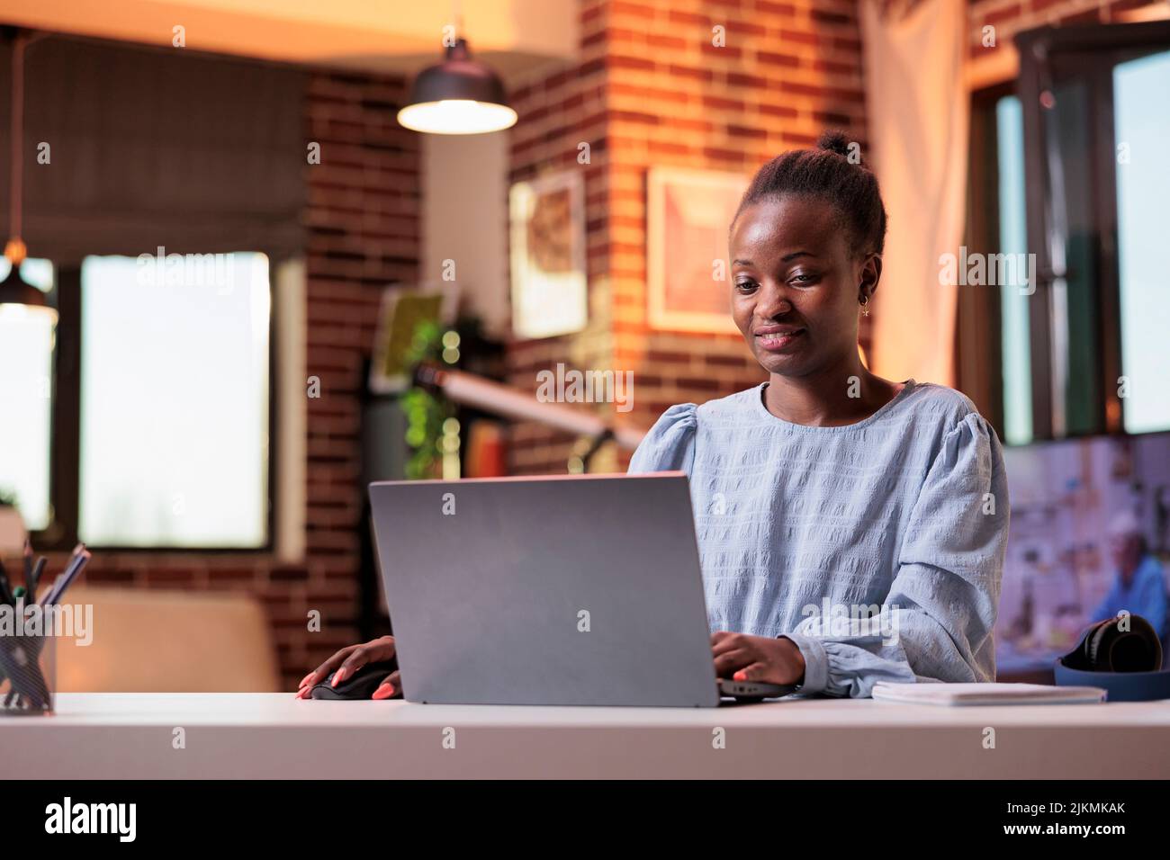 Female african american remote student typing on laptop in room with ...
