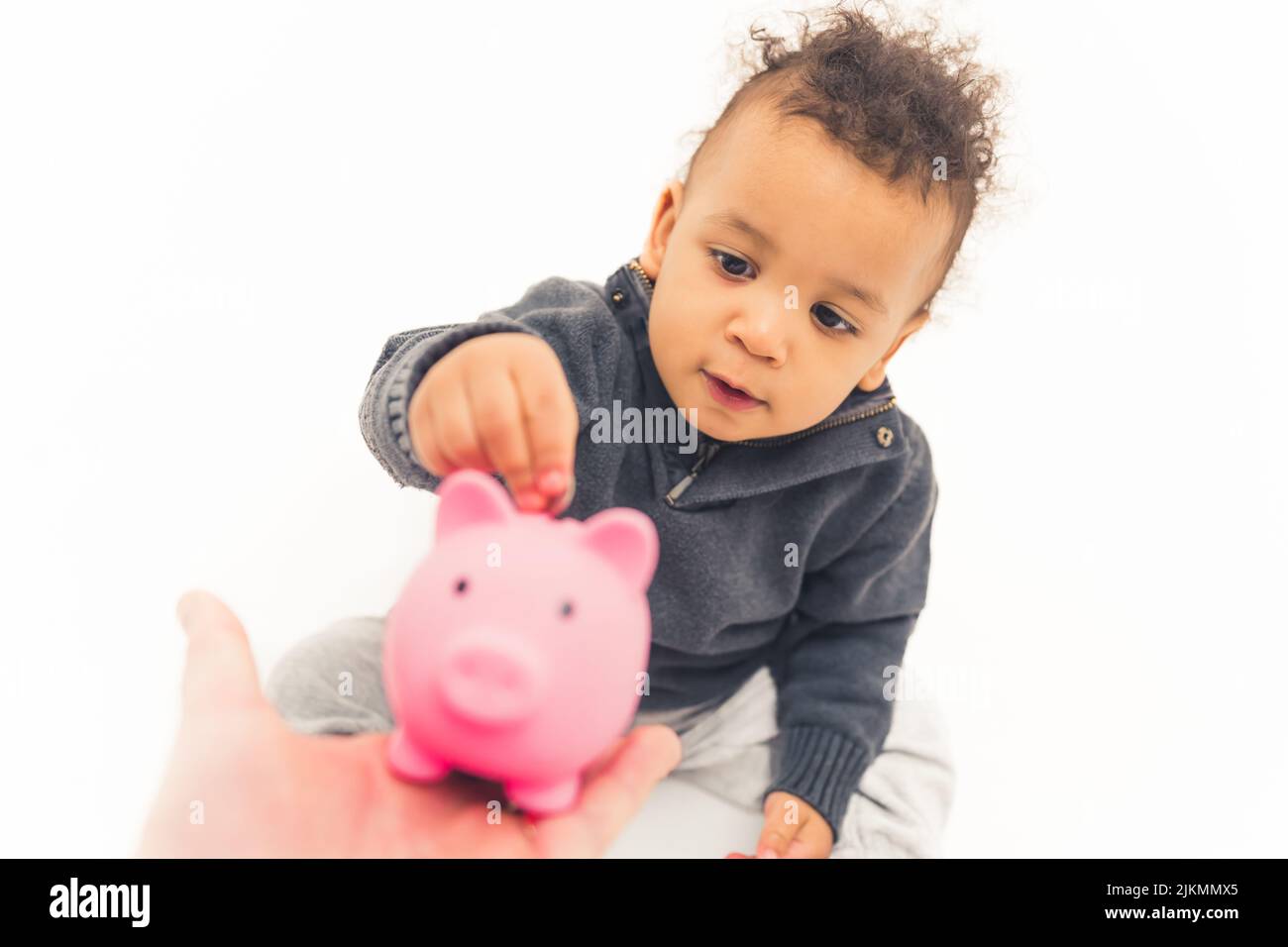 Cute and beautiful small afro american toddler putting a coin into a ...