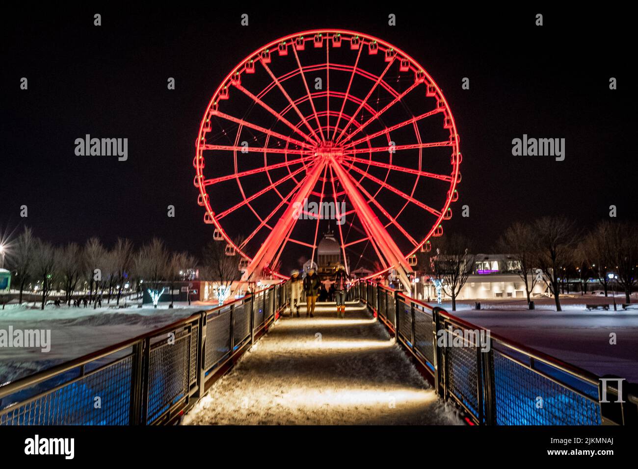 A view of a beautiful red observation wheel in the park at night with ...
