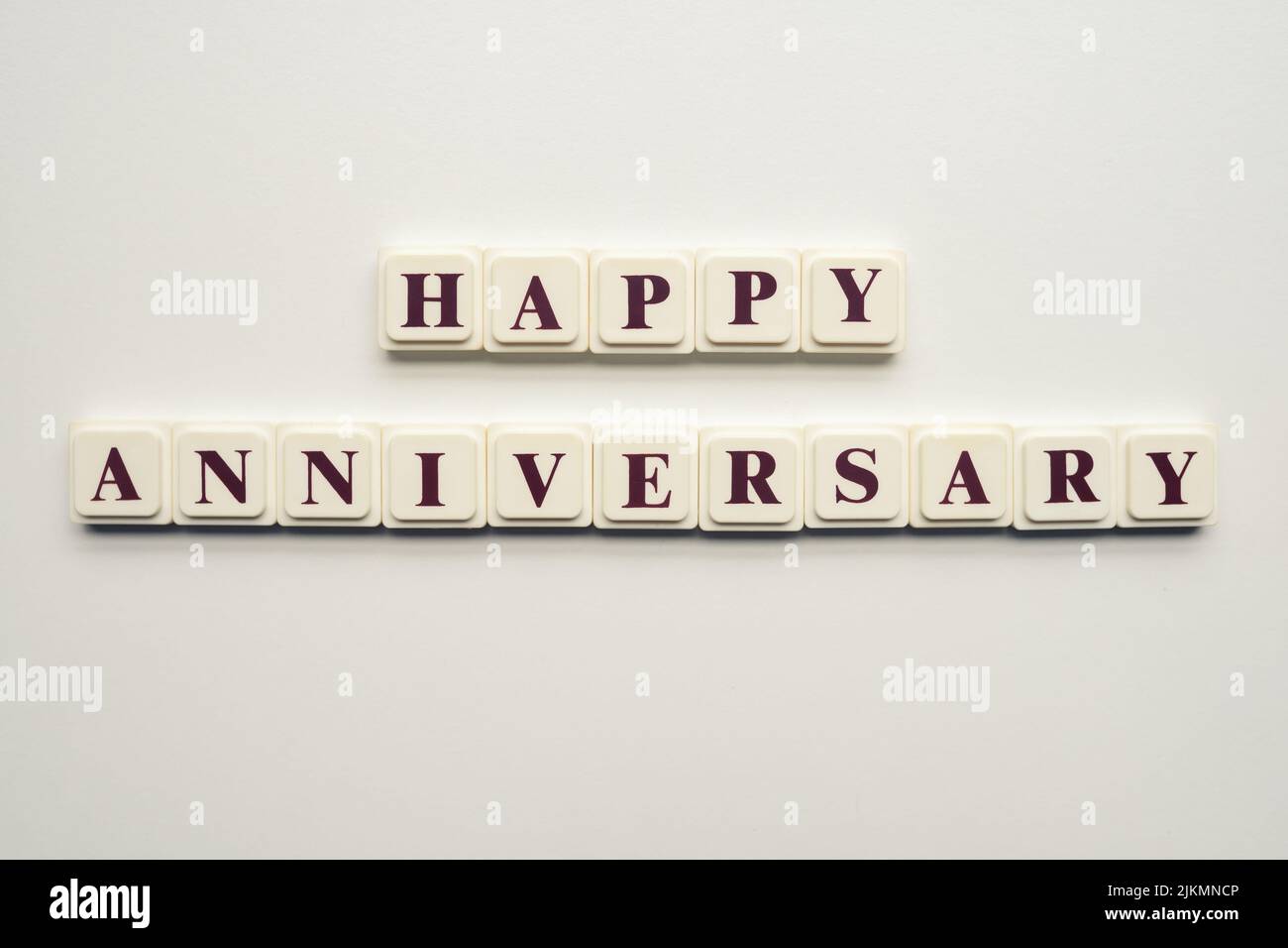 A closeup of scrabble tiles with letters spelling "Happy Anniversary ...