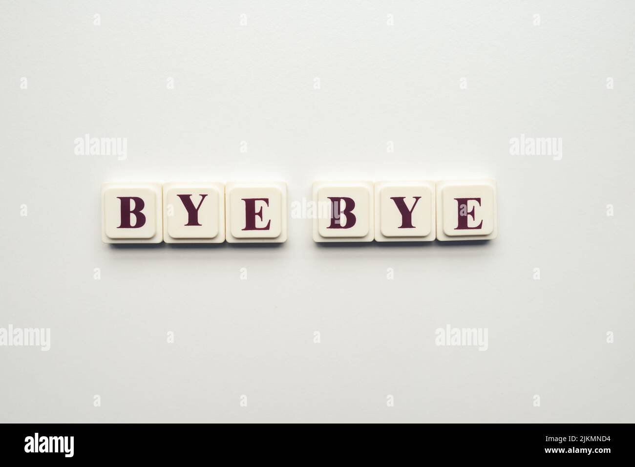A closeup of scrabble tiles with letters spelling the message "Bye Bye ...