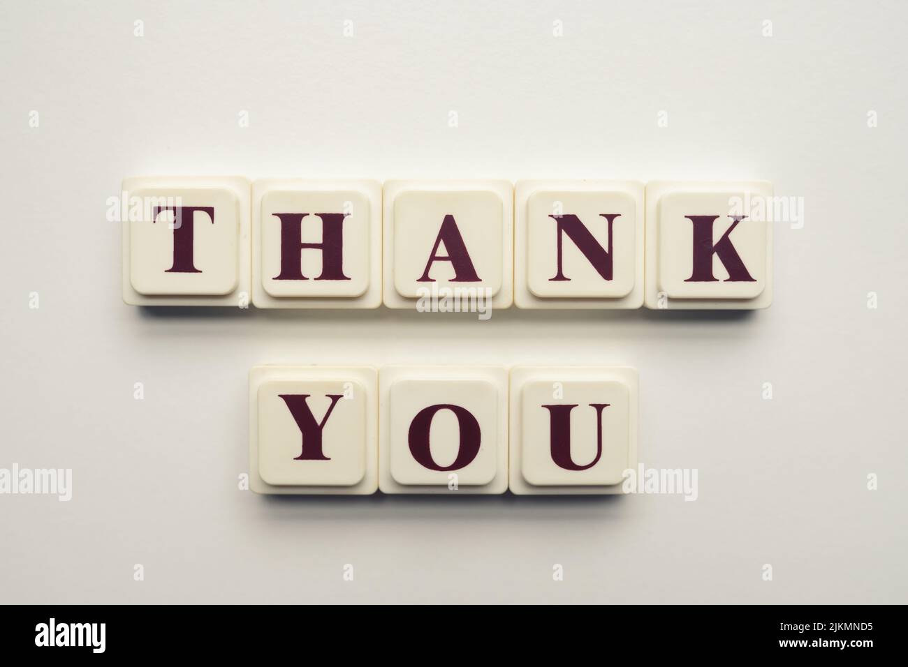 A closeup of scrabble tiles with letters spelling the message "Thank ...