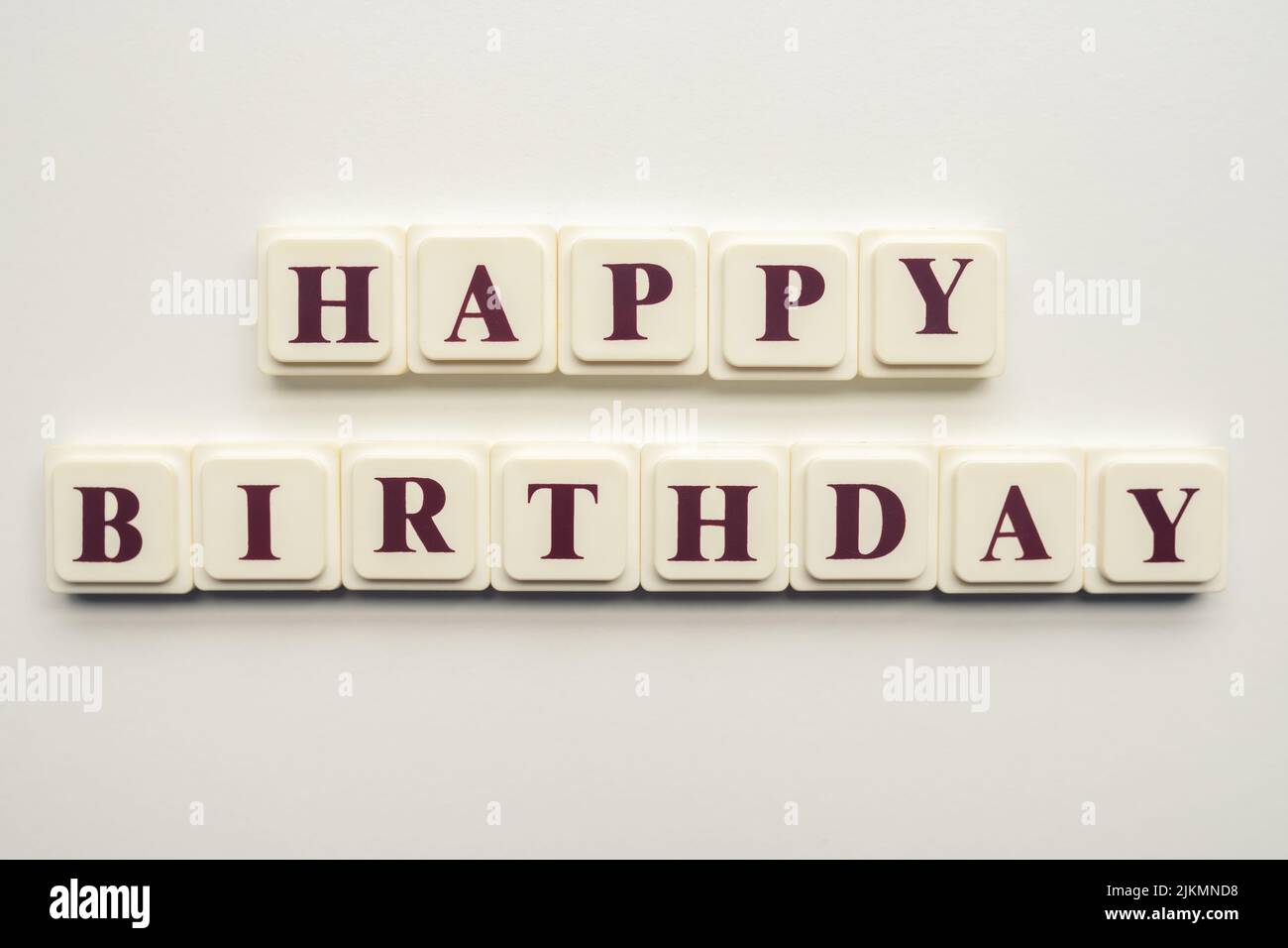 A closeup of scrabble tiles with letters spelling the message "Happy ...