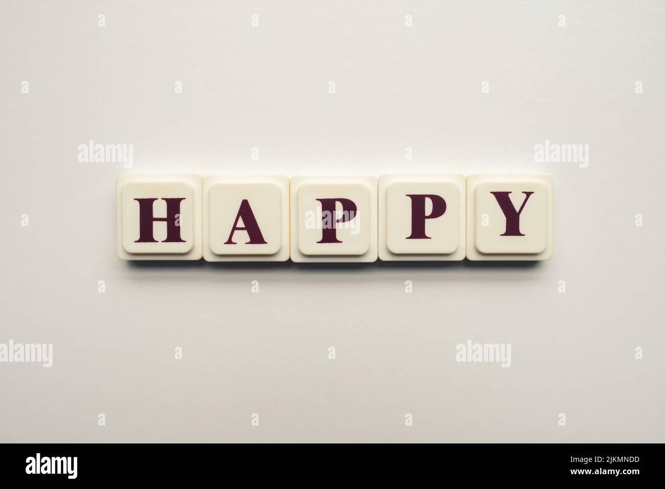 A closeup of scrabble tiles with letters spelling the message "Happy ...
