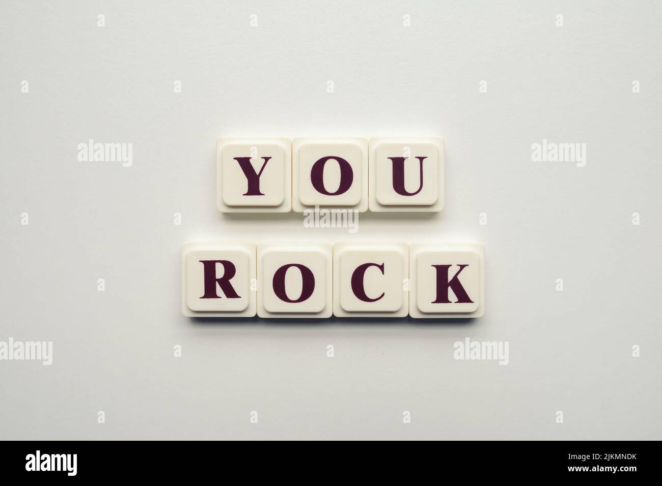 A closeup of scrabble tiles with letters spelling the message "You Rock ...