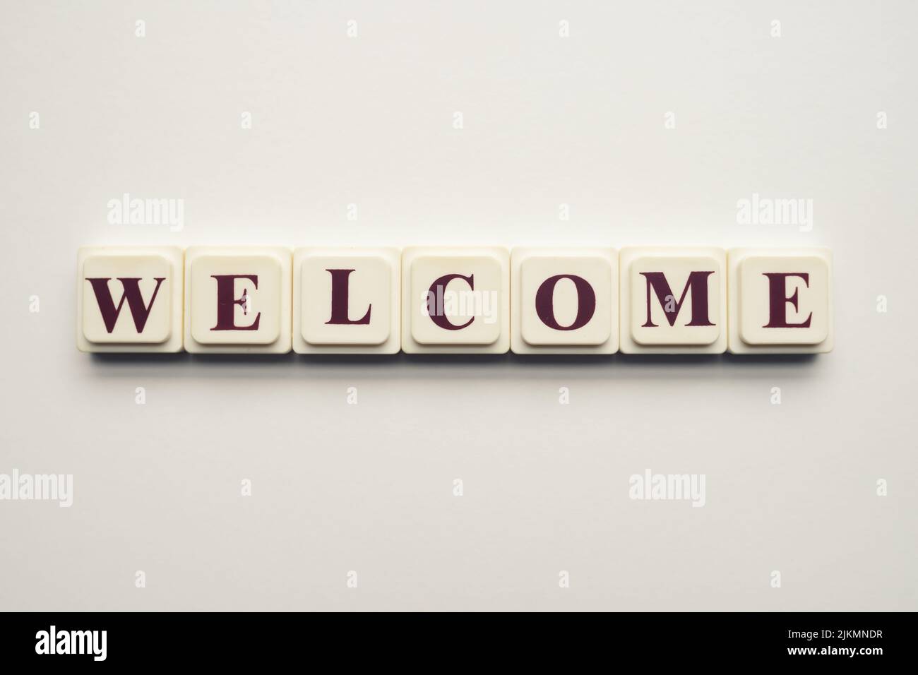 A closeup of scrabble tiles with letters spelling the message "Welcome ...