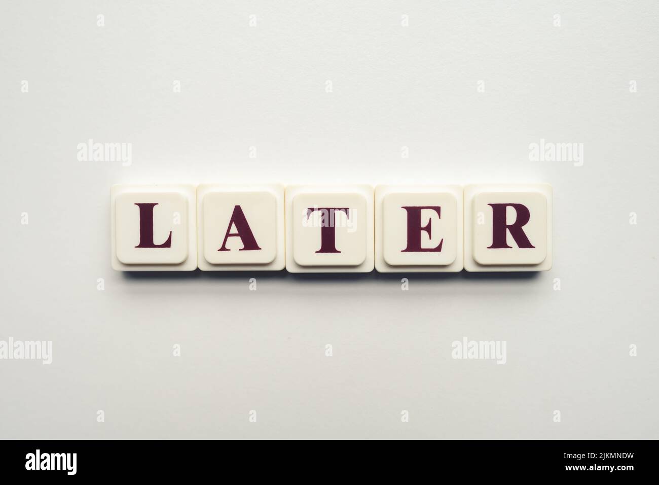 A closeup of scrabble tiles with letters spelling the message "Later ...