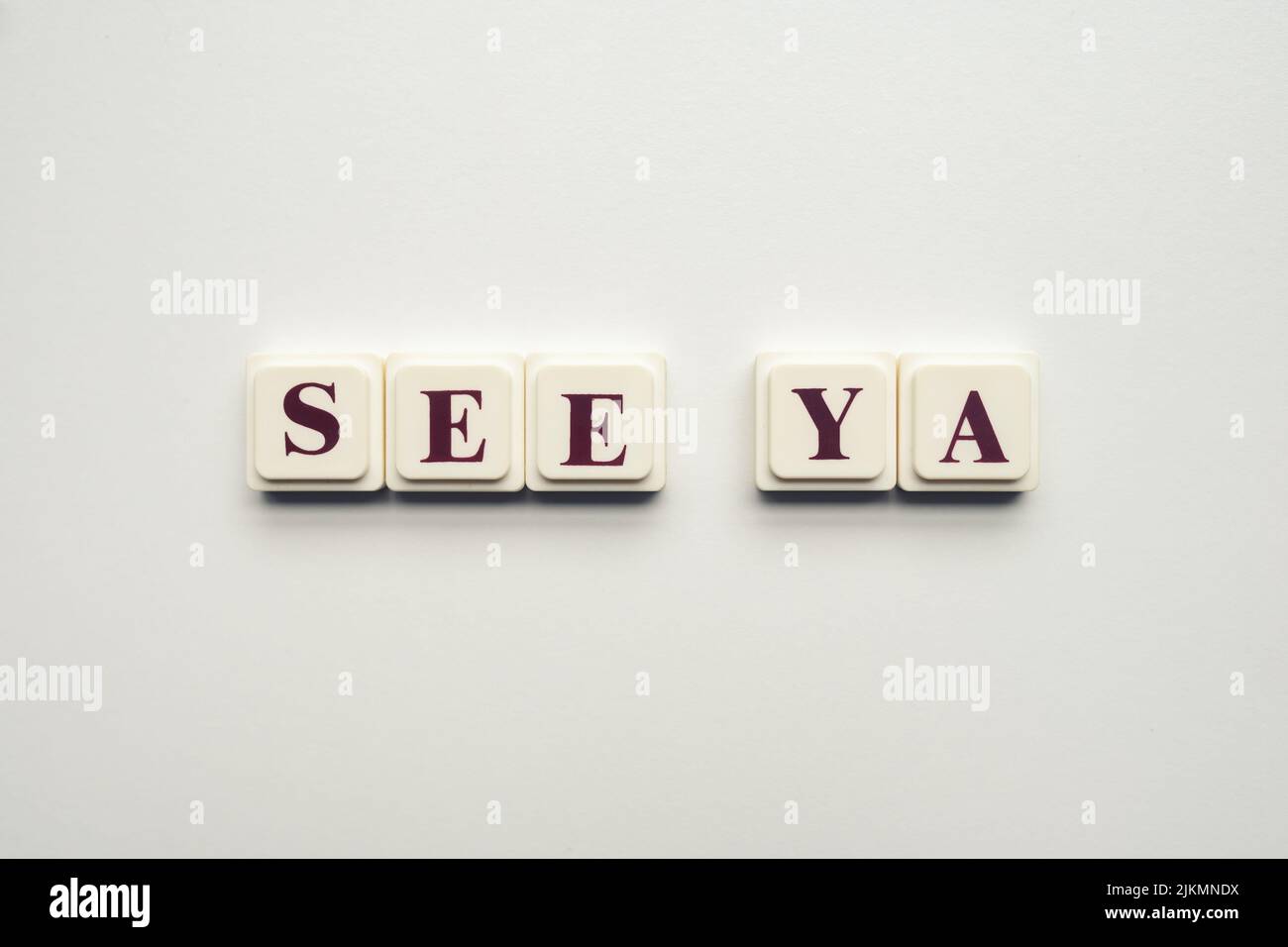 A closeup of scrabble tiles with letters spelling the message "See Ya ...