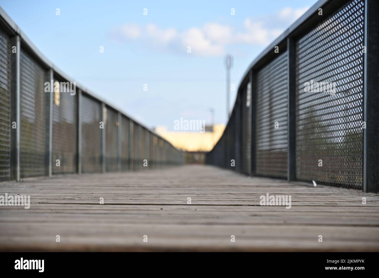 A wooden boardwalk with black metal fences Stock Photo - Alamy