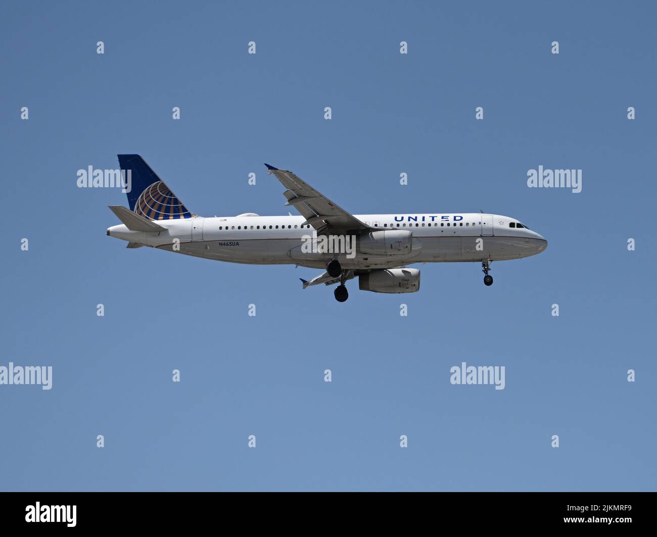 A United Airlines Airbus A320 in flight with a background of blue sky ...