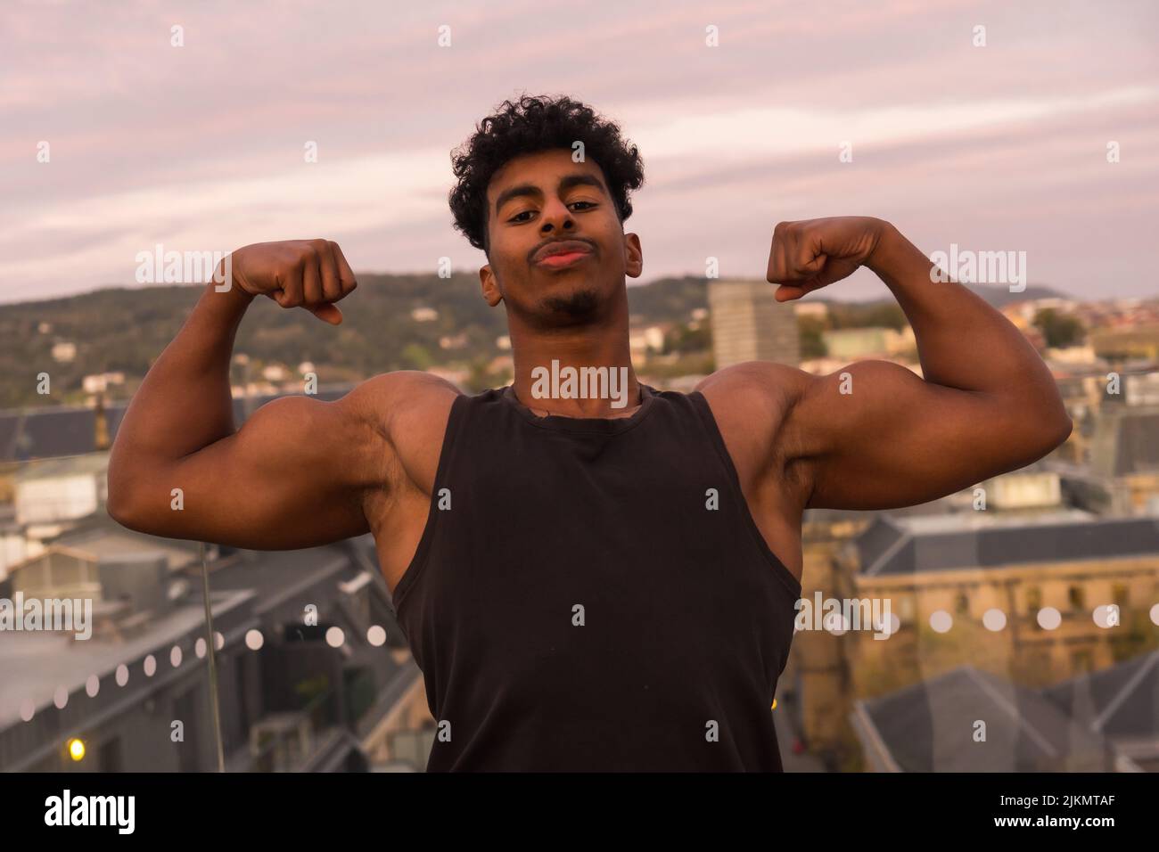 Arab young bodybuilder doing sports in the city, showing off his big ...