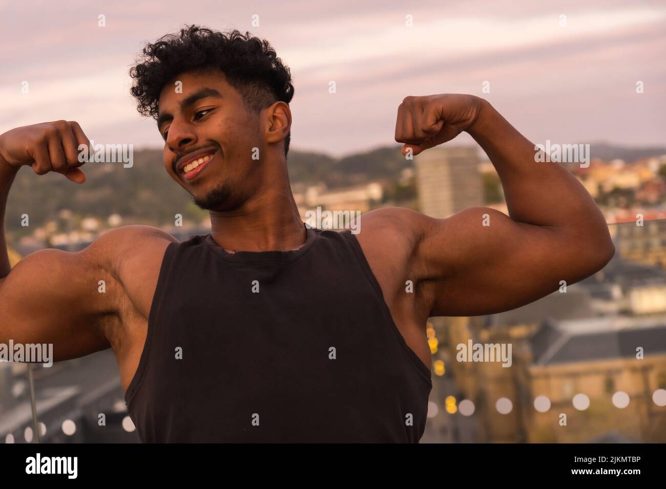 Arab young bodybuilder doing sports in the city, showing off his big arm muscle Stock Photo - Alamy