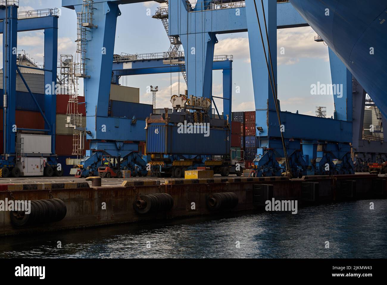 industrial port with containers. Terminal crane loads container on ship ...