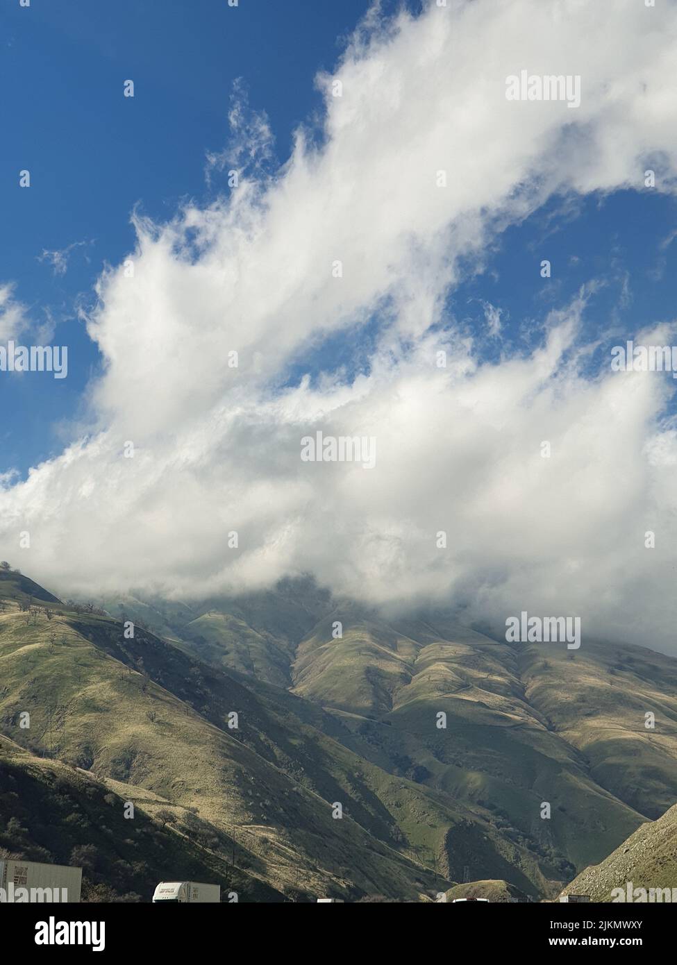 A beautiful sky cloudy scene on rocky grand mountains with little snow ...
